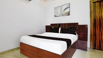 Quarto com cama de madeira, roupa de cama branca, cabeceira de madeira e duas obras de arte na parede.