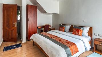 Quarto com cama grande, cabeceira de madeira e mesa de cabeceira.