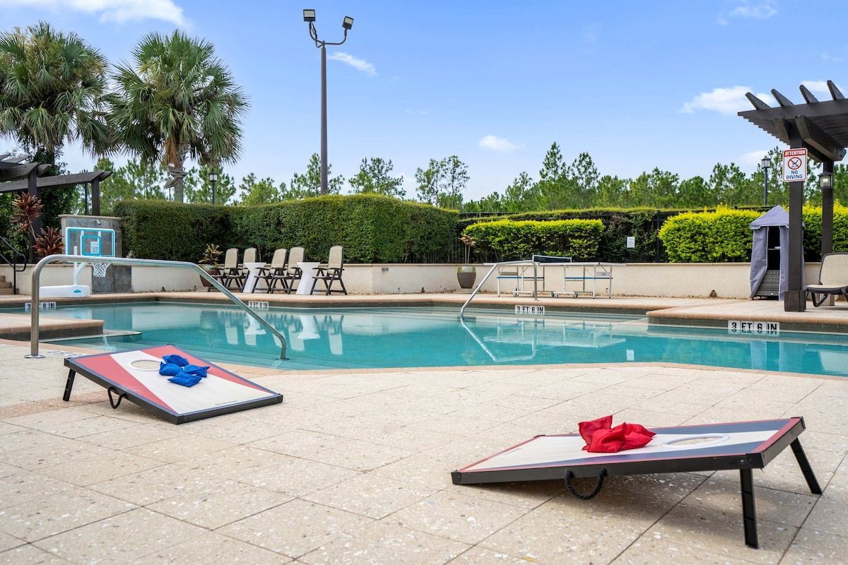 Piscina com espreguiçadeiras e quadra de basquete.