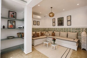Sala de estar com sofá, mesa de centro e objetos decorativos.