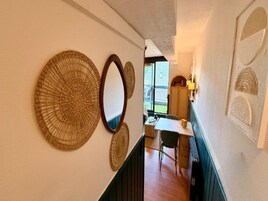 Um corredor com área de refeições, com mesa e cadeiras, e decoração nas paredes.