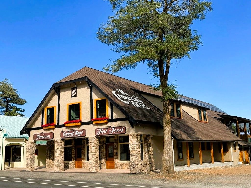 Um edifício com fachada de pedra, com várias placas incluindo 'Inn', 'Central Hotel' e 'Fine Food'.