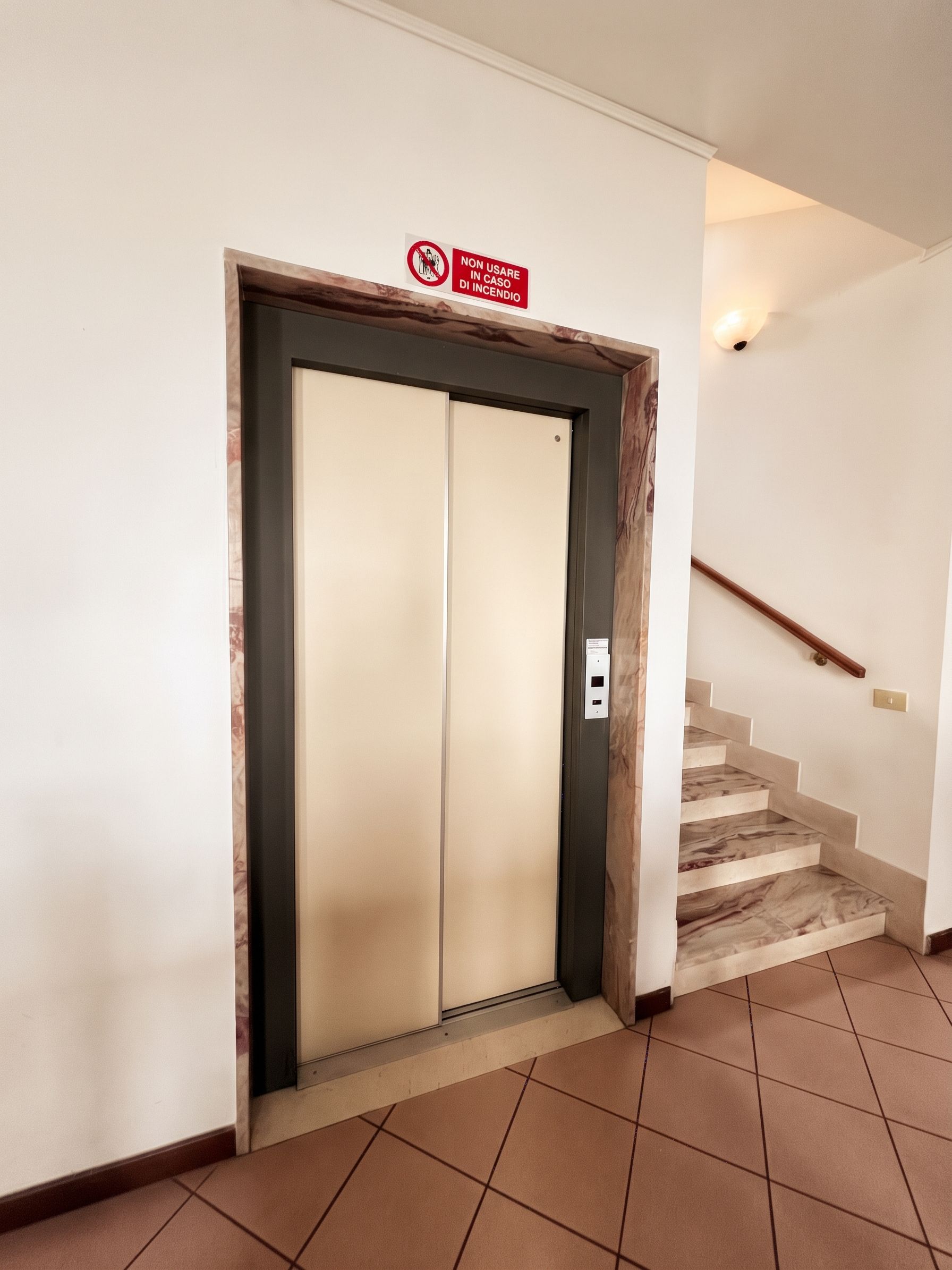 Um elevador com uma placa que proíbe o uso em caso de incêndio.