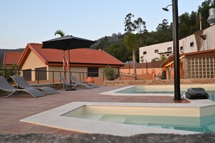 Uma área de piscina com espreguiçadeiras e um salva-vidas.