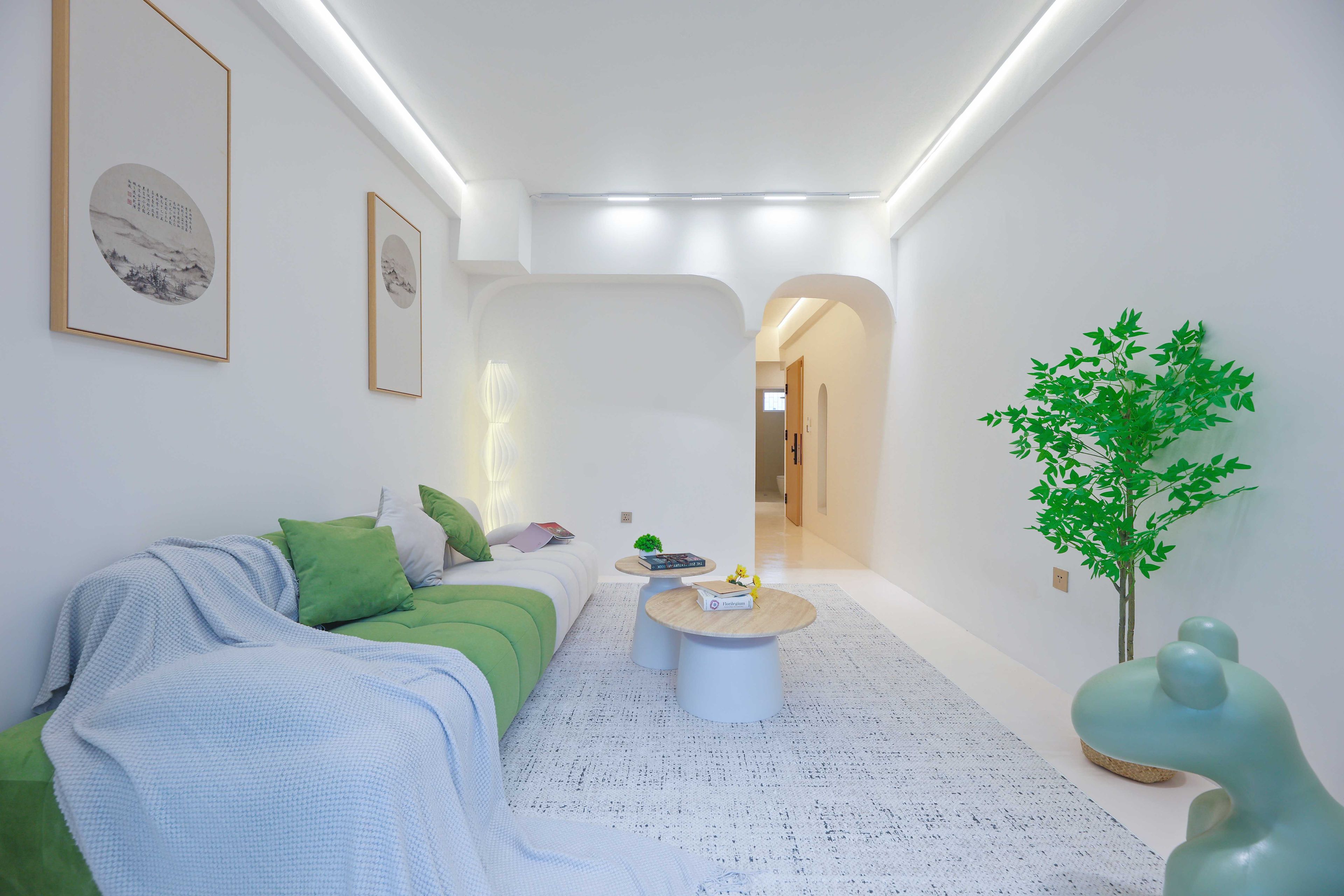 Uma sala de estar moderna com sofá, mesa de centro e planta verde.