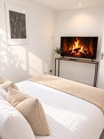 Quarto com cama, lareira e um quadro pendurado na parede.