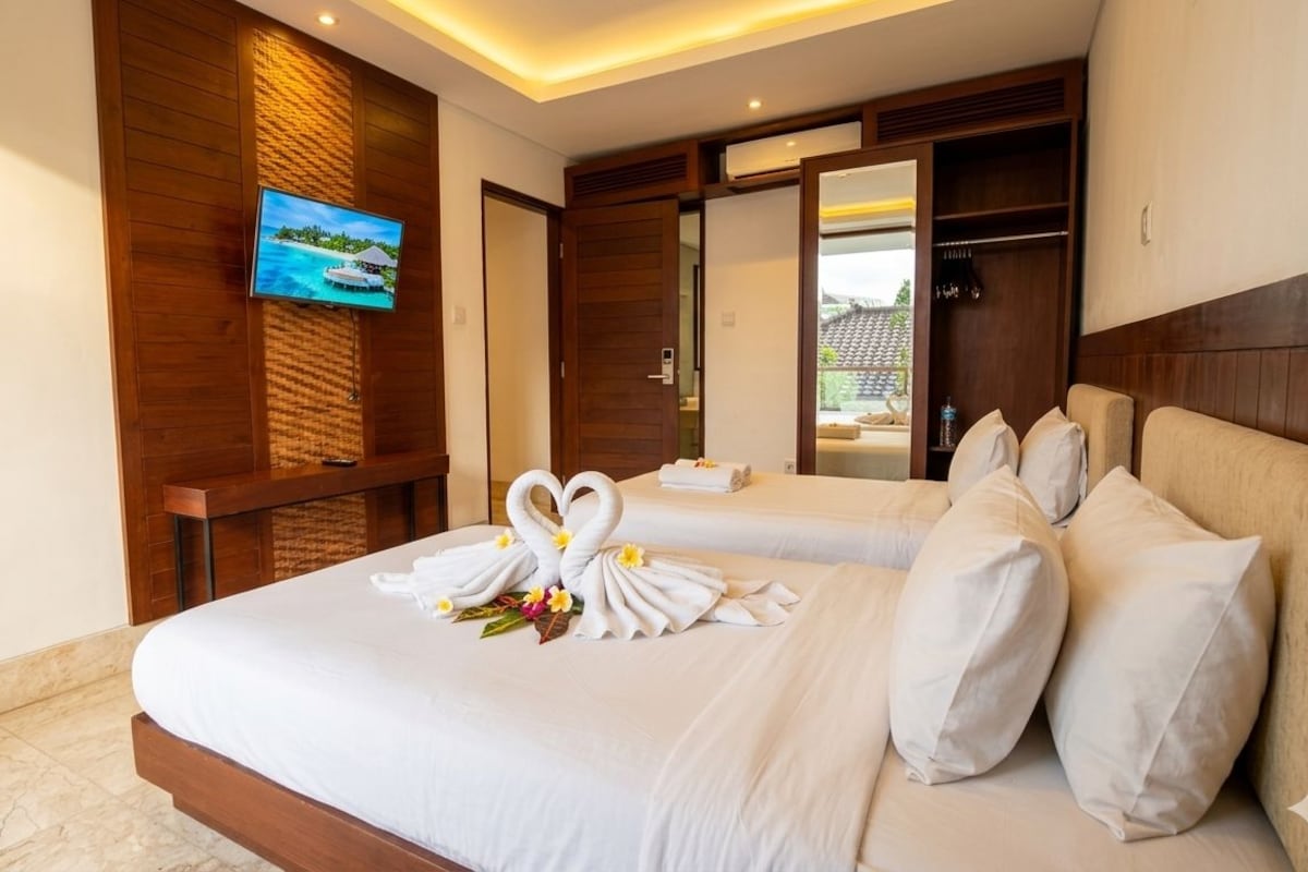 Quarto de hotel com cama, televisão e vista para o exterior.