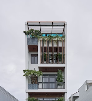 Um edifício com várias andares, varandas, janelas amplas e um telhado plano.