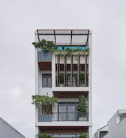 Um edifício com várias andares, varandas, janelas amplas e um telhado plano.