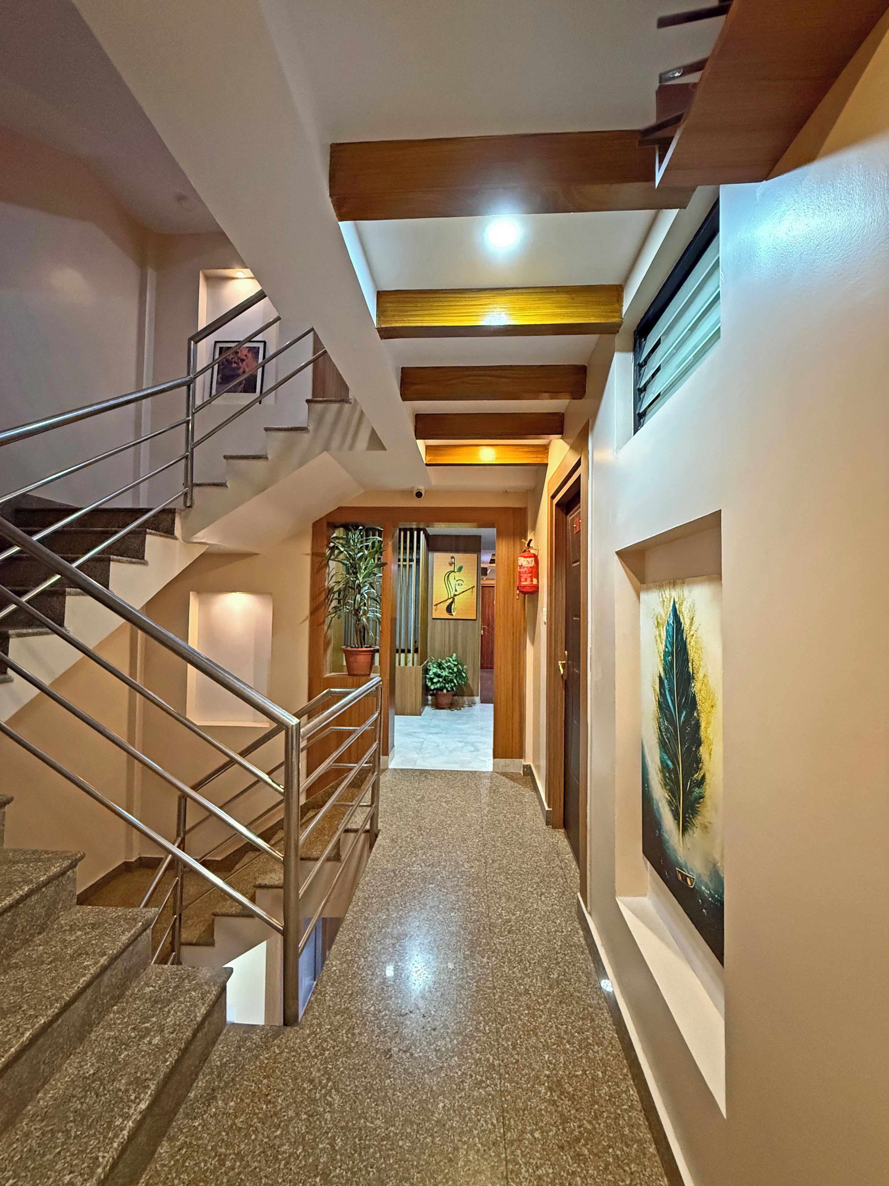 Um interior moderno com escada, corredor e um quadro na parede.