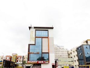 Um edifício moderno com um letreiro chamativo para 'GOLDENSIP BAR'.