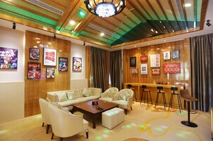 Uma sala de estar moderna com um conjunto de sofás, uma mesa de centro e um espaço de bar com banquetas.