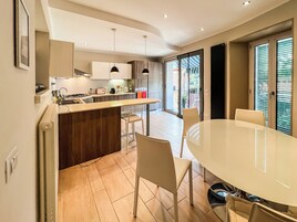 Cozinha moderna com ilha central, mesa de jantar e cadeiras.