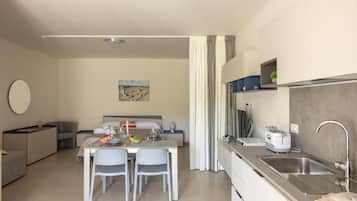 Cozinha moderna com espaço para refeições, uma cama e um banheiro.