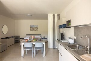 Cozinha moderna com espaço para refeições, uma cama e um banheiro.