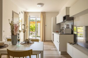 Cozinha moderna com área de refeições, micro-ondas embutido e vista para o exterior.
