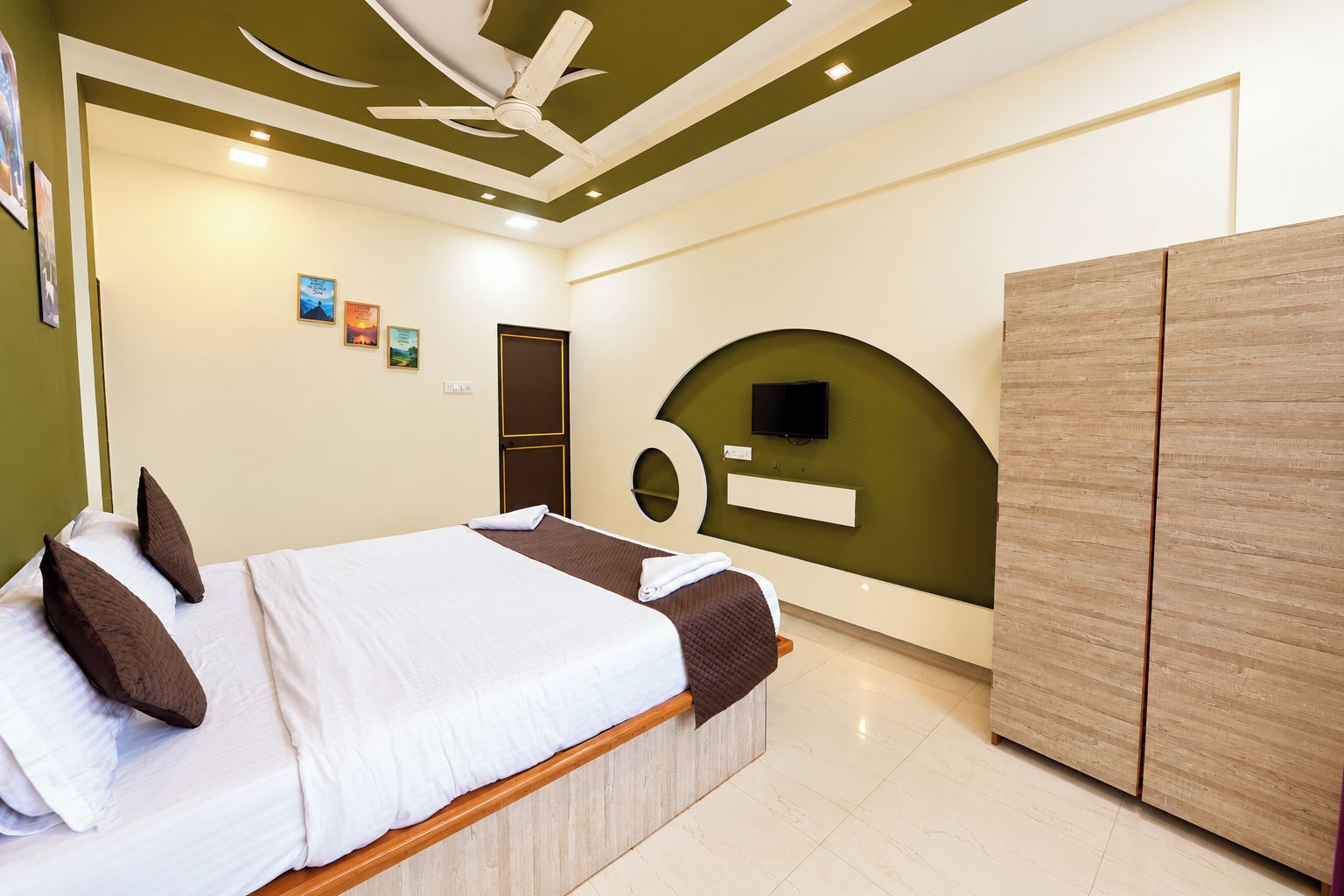 Quarto moderno com cama, guarda-roupa, televisão e ventoinha de teto.