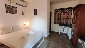 Quarto com cama, mesa de cabeceira e ar-condicionado fixado na parede.