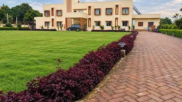 Um hotel moderno com um caminho de entrada calçado e um gramado bem cuidado.