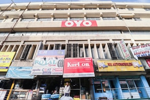 Um edifício com várias placas comerciais, incluindo uma placa grande da 'OYO'.