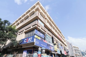 Um edifício com vários andares e letreiros comerciais, incluindo um grande letreiro 'CENT'.