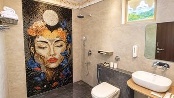 Uma casa de banho com parede em mosaico, sanita, chuveiro e lavatório.