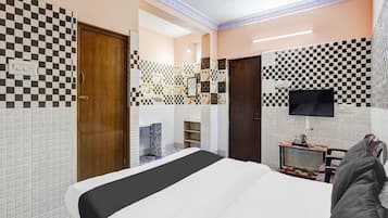 Quarto de hotel com cama, televisão, espelho e ventoinha no teto.