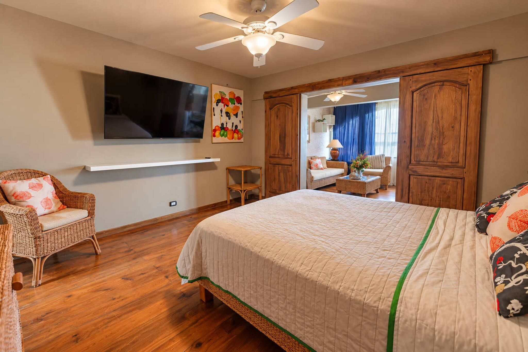 Quarto com cama, televisão, cadeira, escrivaninha e guarda-roupa.