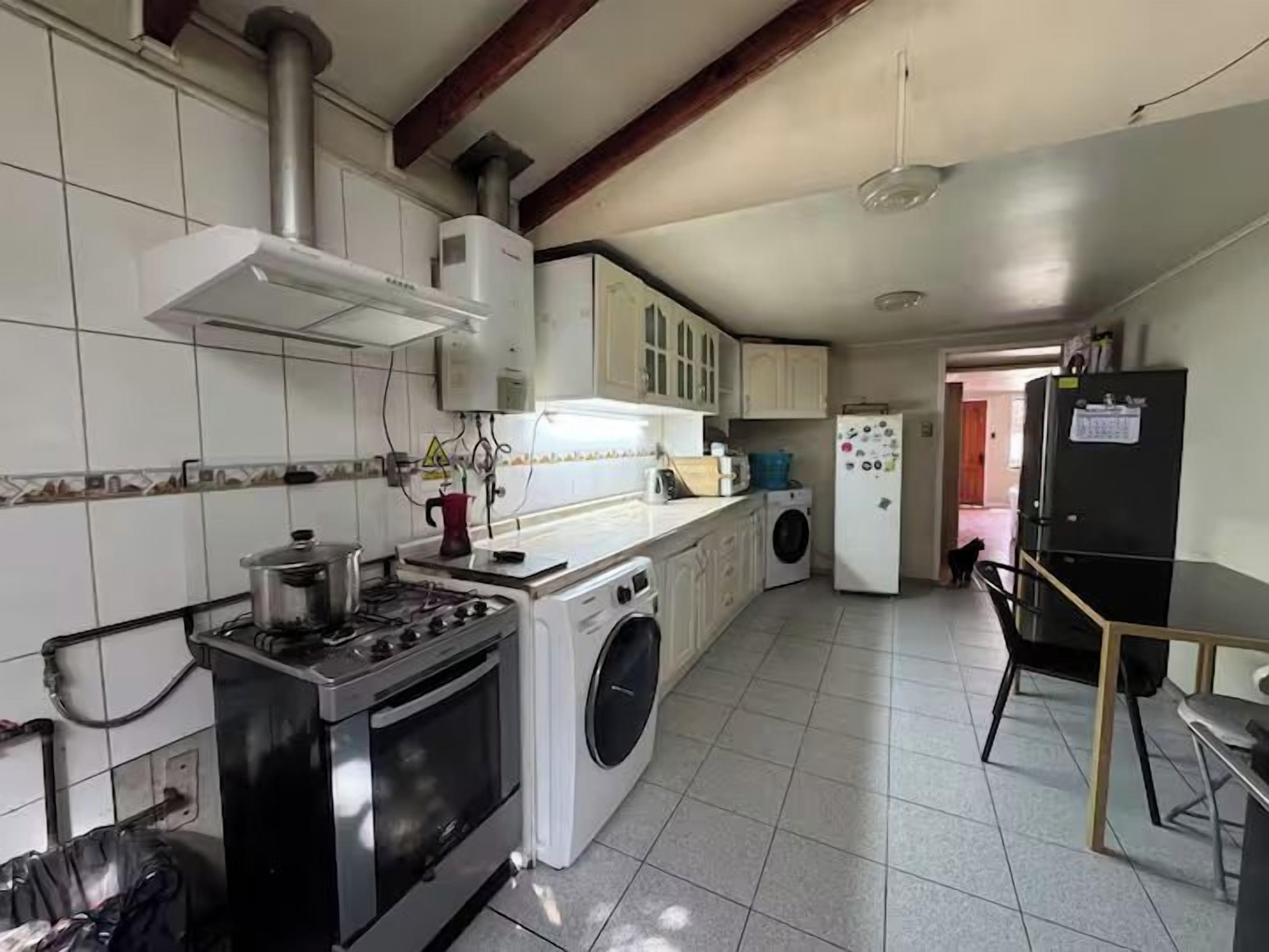 Cozinha equipada com fogão, máquina de lavar e frigorífico.