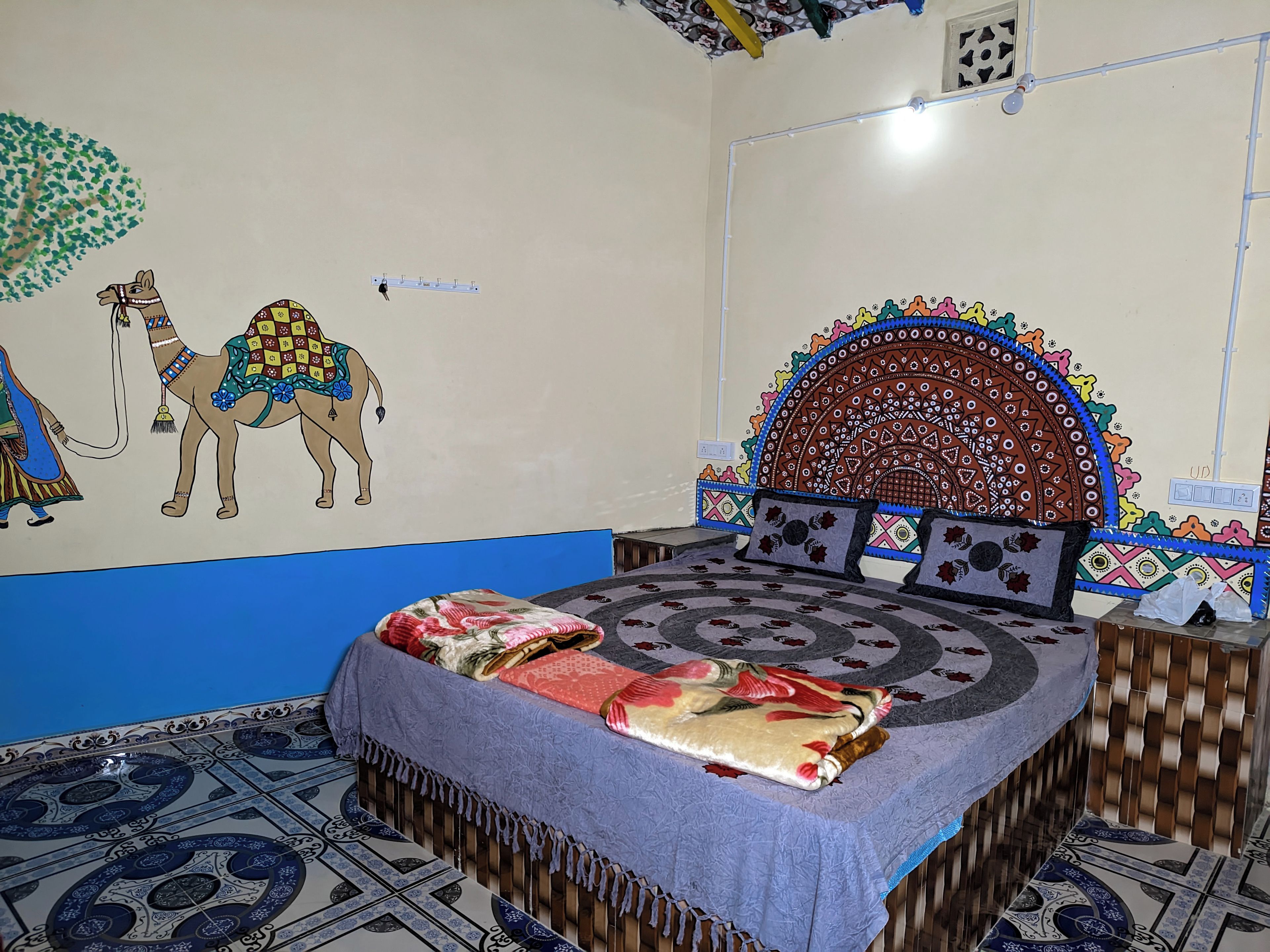 Quarto com cama, painel decorativo na parede e piso estampado.