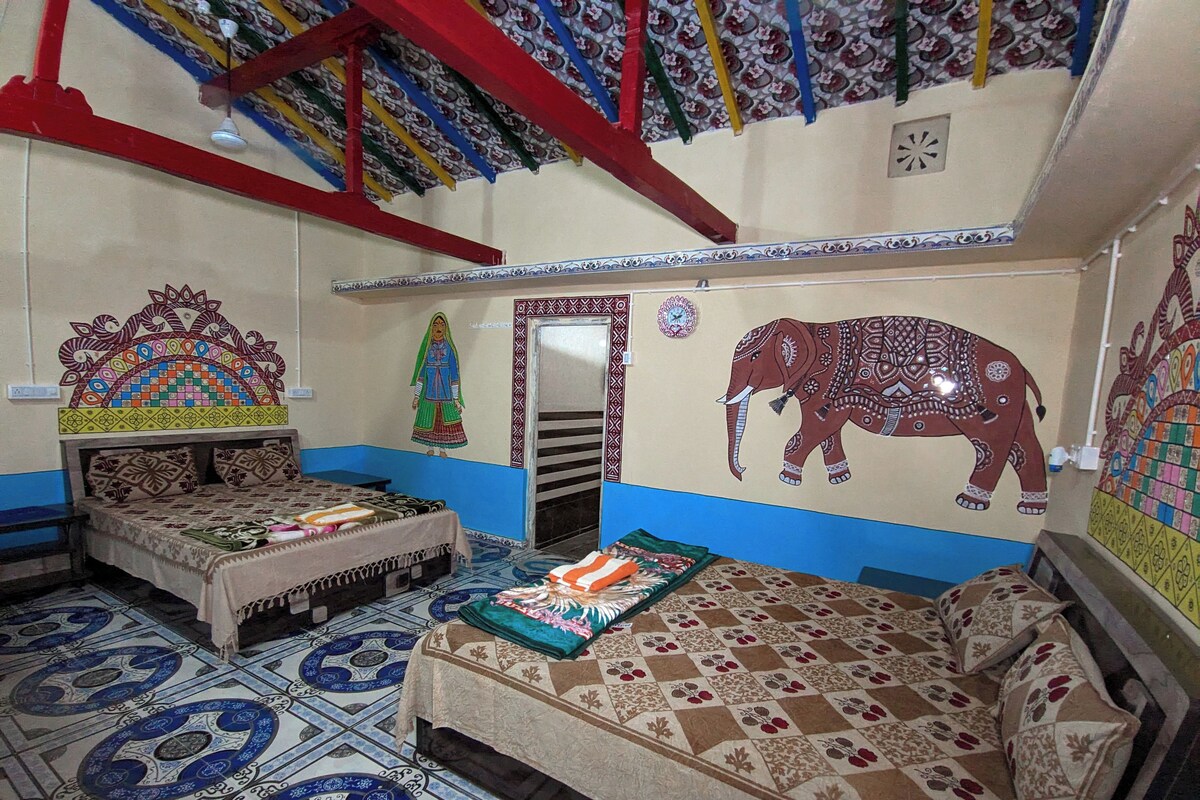 Quarto com duas camas, um mural de elefante na parede e piso estampado.