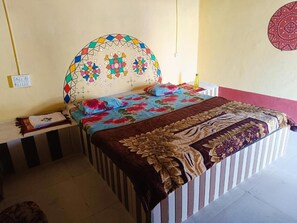 Uma cama com cabeceira colorida e roupa de cama florida.