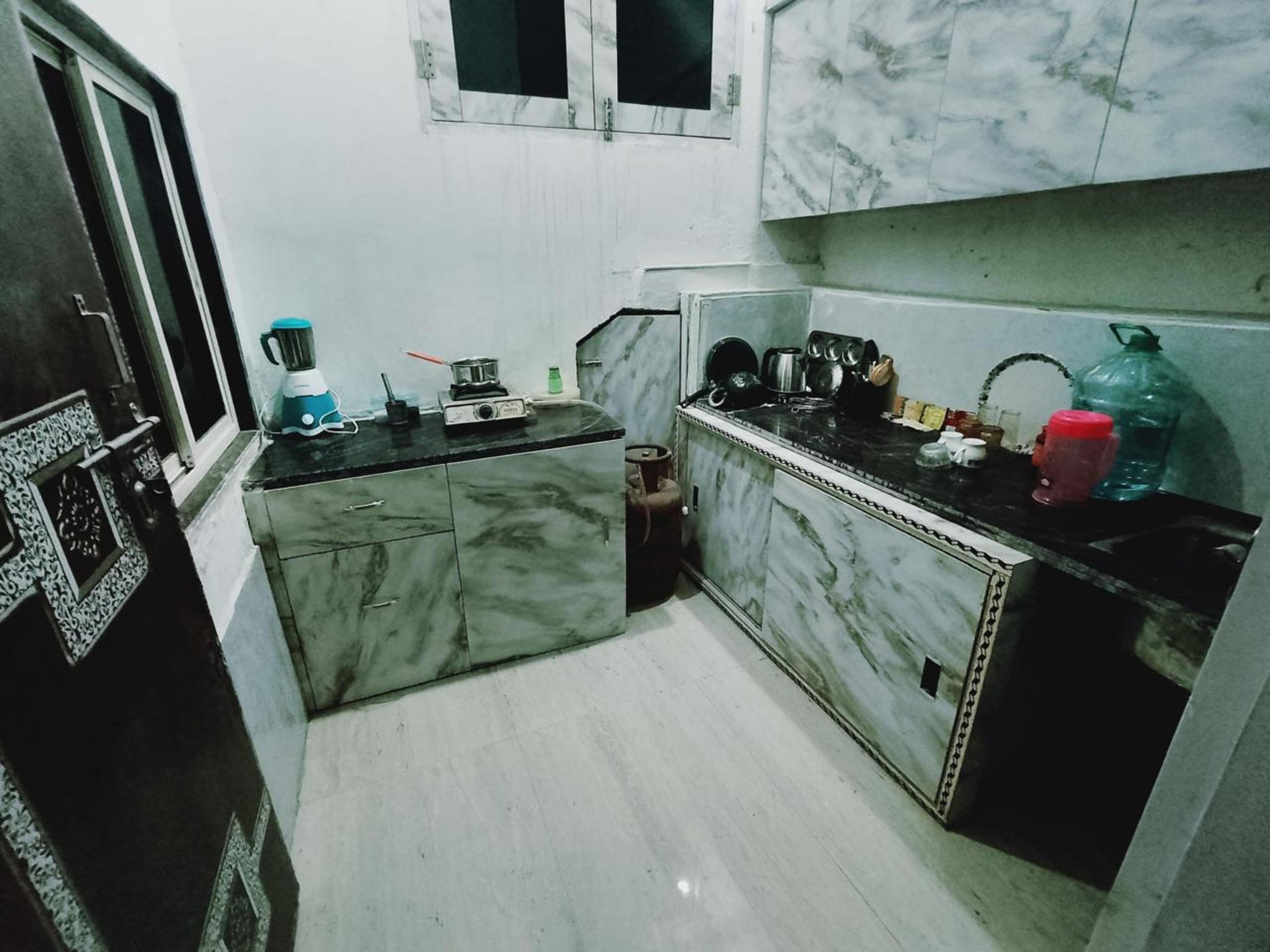 Uma cozinha compacta com bancadas de mármore, fogão embutido e pia.