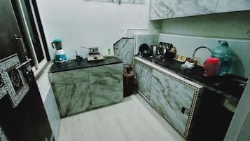 Uma cozinha compacta com bancadas de mármore, fogão embutido e pia.