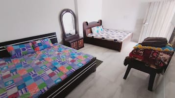 Quarto com cama, penteadeira, espelho e mesa de cabeceira.