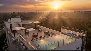 Terraço no telhado com piscina, área de estar ao ar livre e vista para a paisagem circundante.