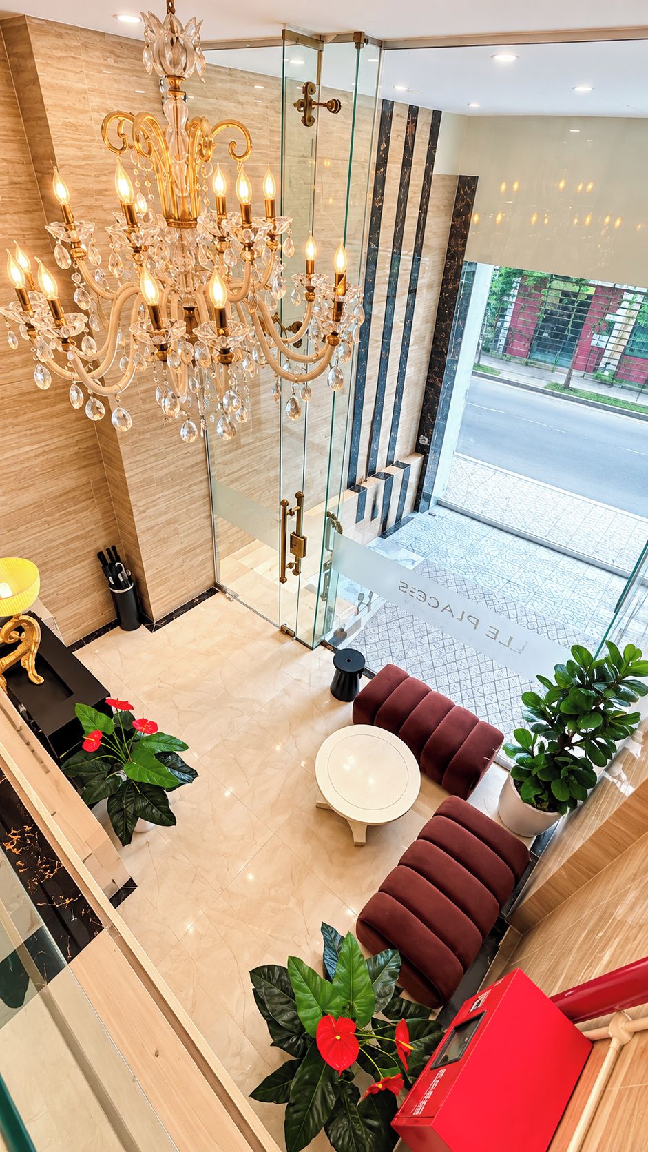 Interior moderno com lustre, área de estar e vista para a rua.