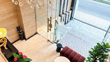 Interior moderno com lustre, área de estar e vista para a rua.