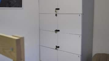 Um armazém branco com vários compartimentos, um quadro na parede e uma cadeira no canto.