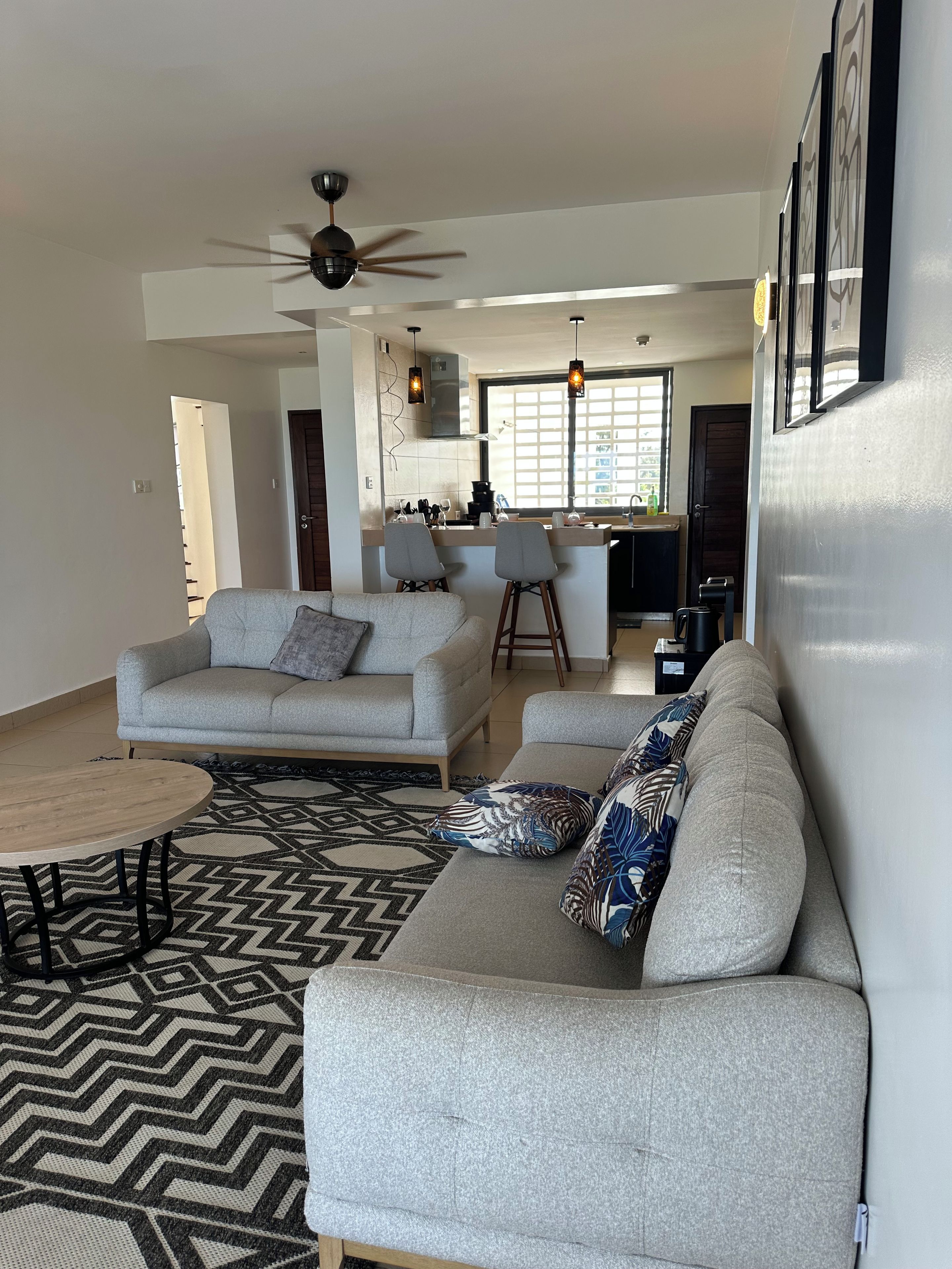 Uma sala de estar moderna com sofá, mesa de centro e tapete estampado.