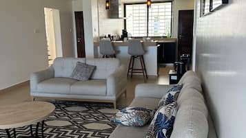 Uma sala de estar moderna com sofá, mesa de centro e tapete estampado.
