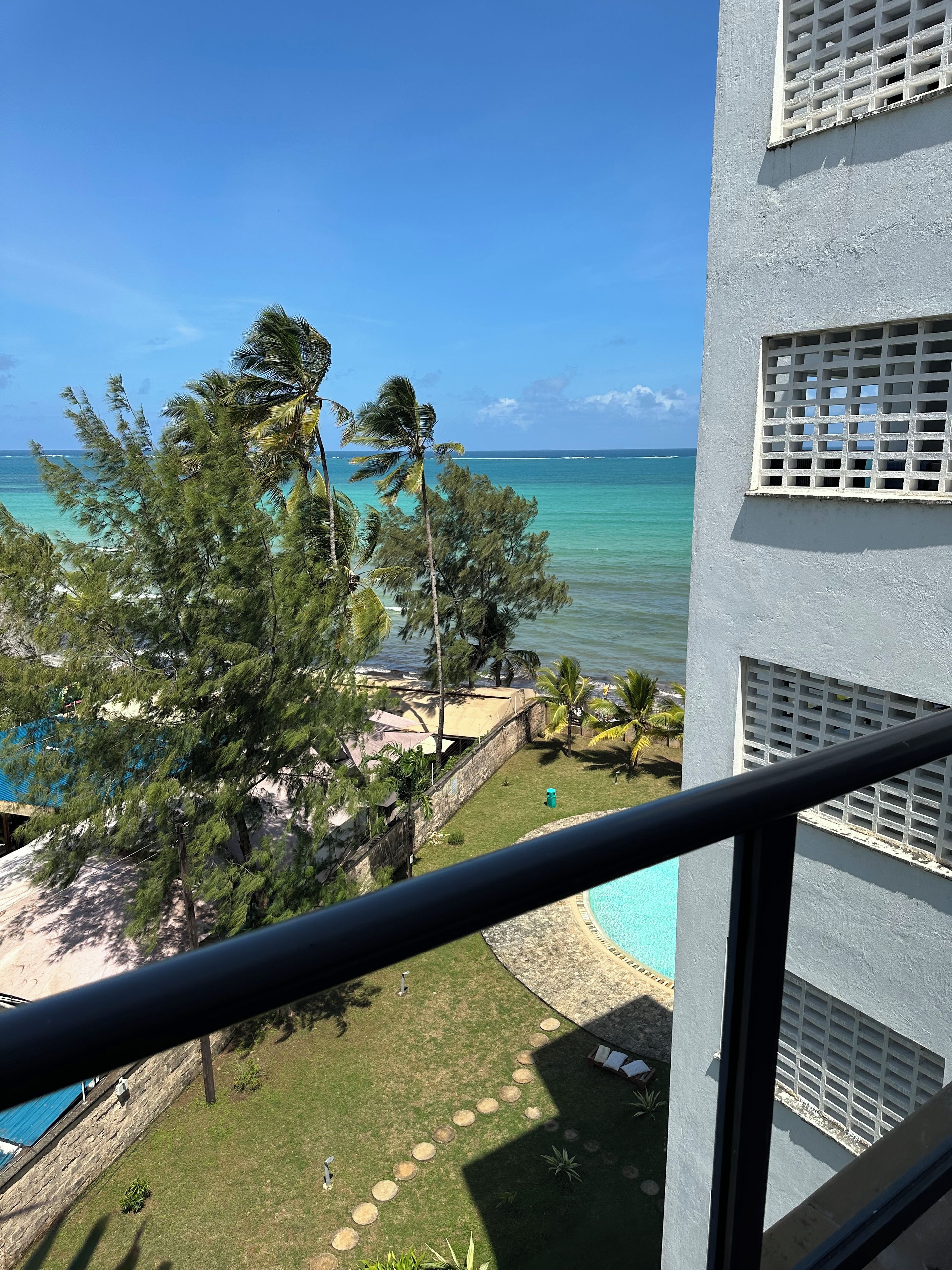 Uma varanda com vista para o oceano e uma piscina.