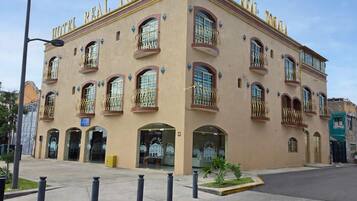 Um hotel com fachada clássica, várias varandas e grandes janelas.