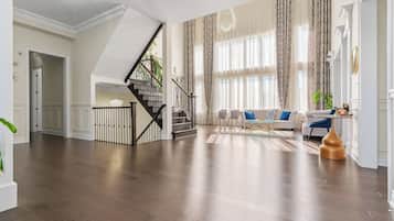 Uma sala de estar ampla com escada, sofá e mesa de centro.