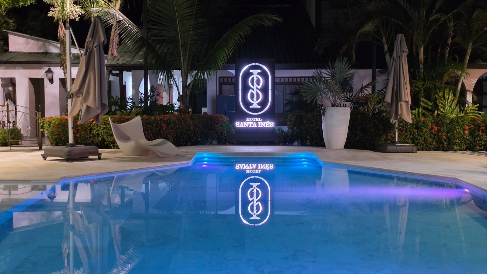 Área de piscina de hotel, com placa indicando 'SANTA INES HOTEL' e logotipo de 'SEVILLA HOTEL'.