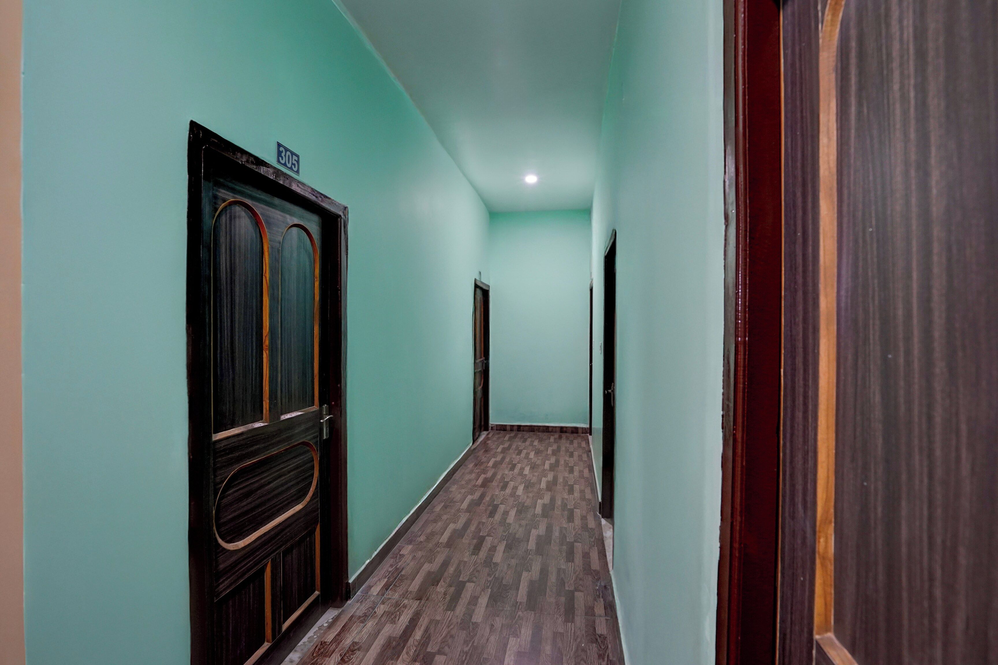 Corredor com porta de madeira identificada com o número '305' e piso de madeira.