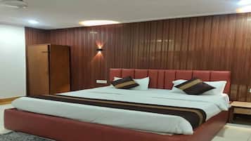 Quarto com cama grande, guarda-roupa e luminária na parede.