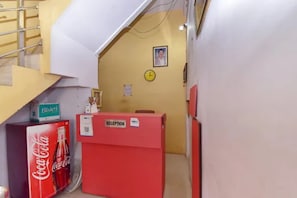 Uma receção com um frigorífico Coca-Cola, um relógio e um quadro emoldurado na parede.