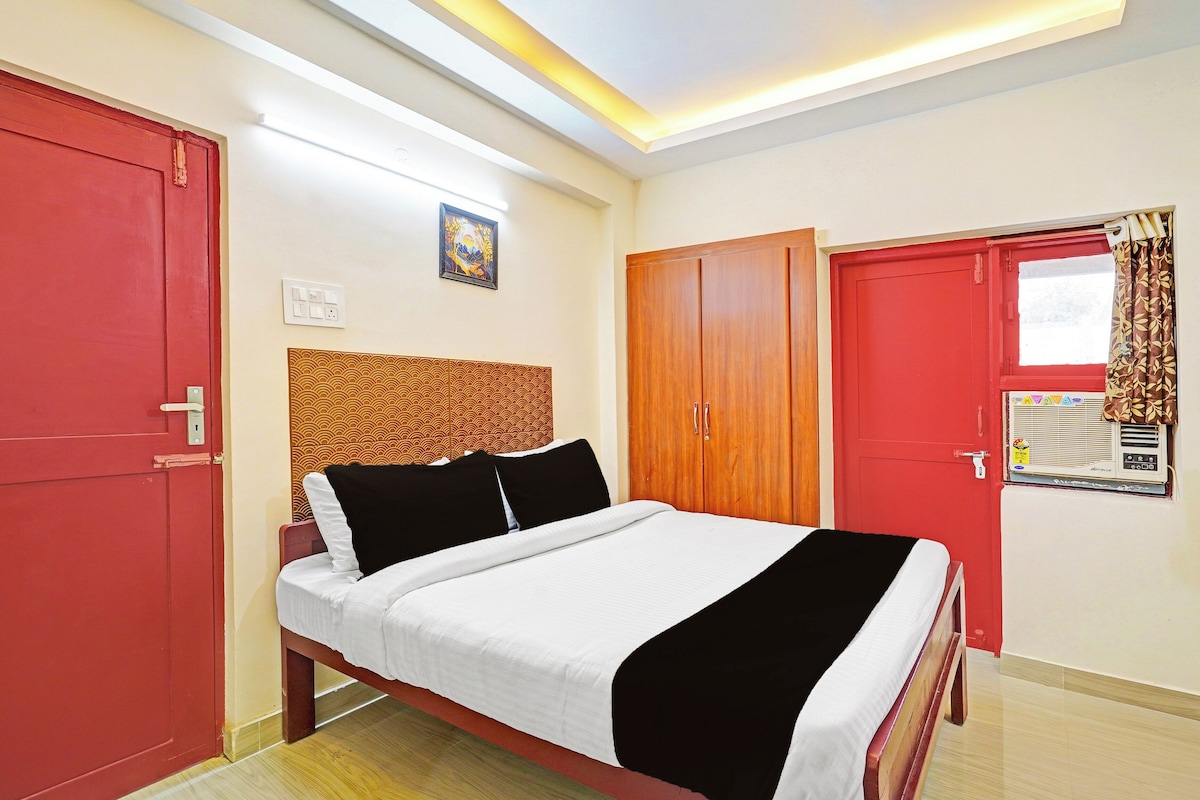 Quarto com cama, guarda-roupa, porta e janela com cortinas.