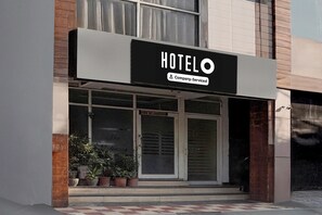 Entrada de hotel com placa que diz 'HOTEL Company-Serviced'.